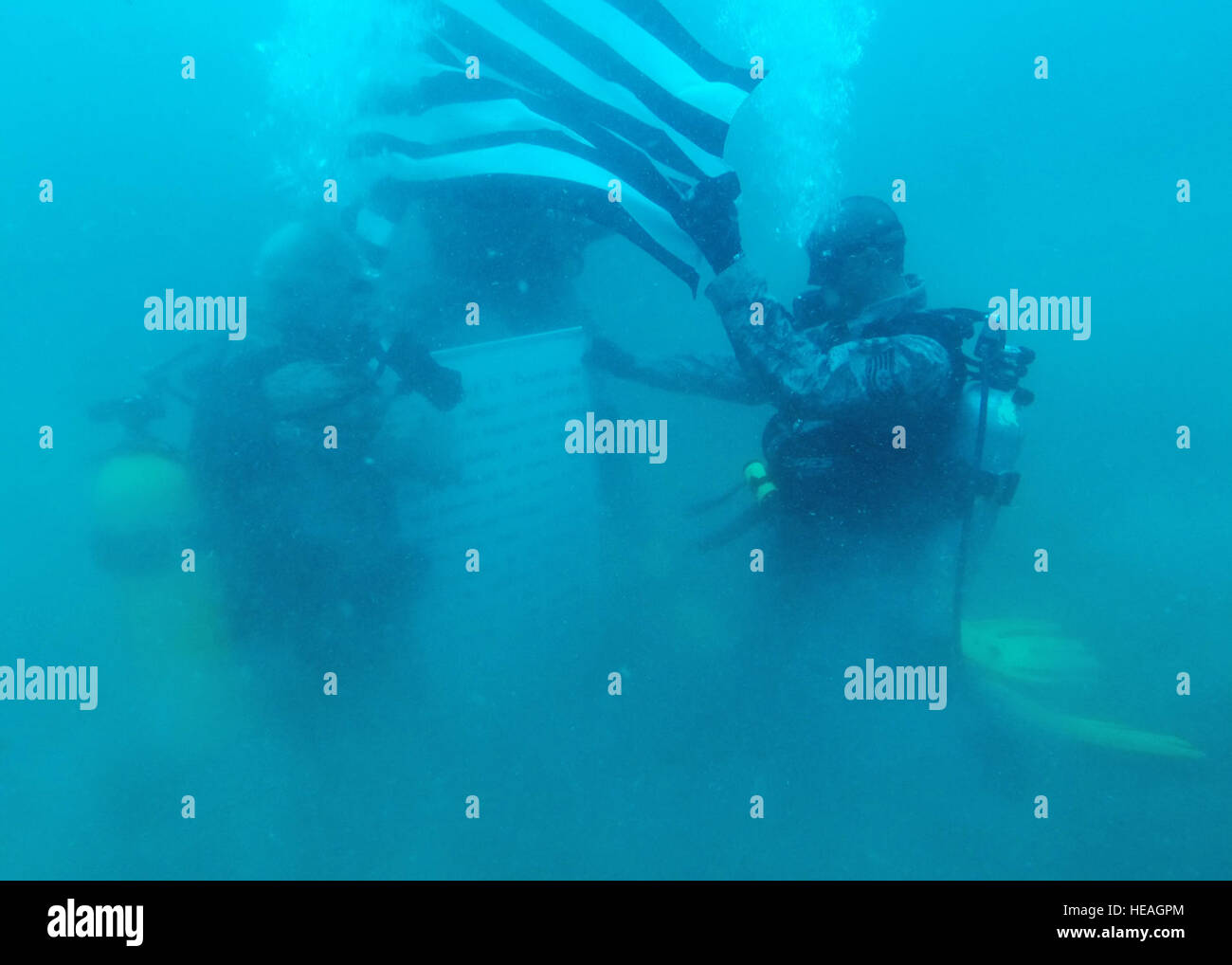 A re-enlistment ceremony is conducted underwater at 70 feet by a ...