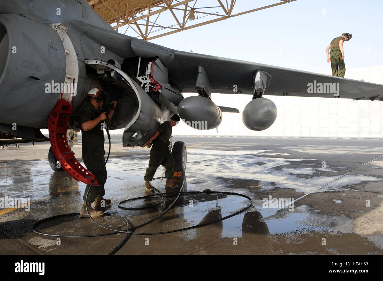 (Left to right) Cpl. Shelby Coville uses a high-pressure water spray to ...
