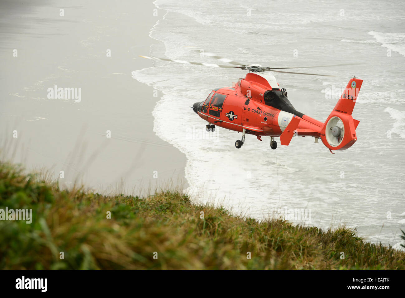 An aircrew aboard an MH-65 Dolphin helicopter flies near the North Head ...
