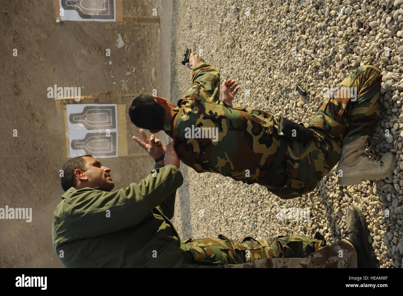 Iraqi police Warrant Officer Ahmed instructs a student on proper pistol ...