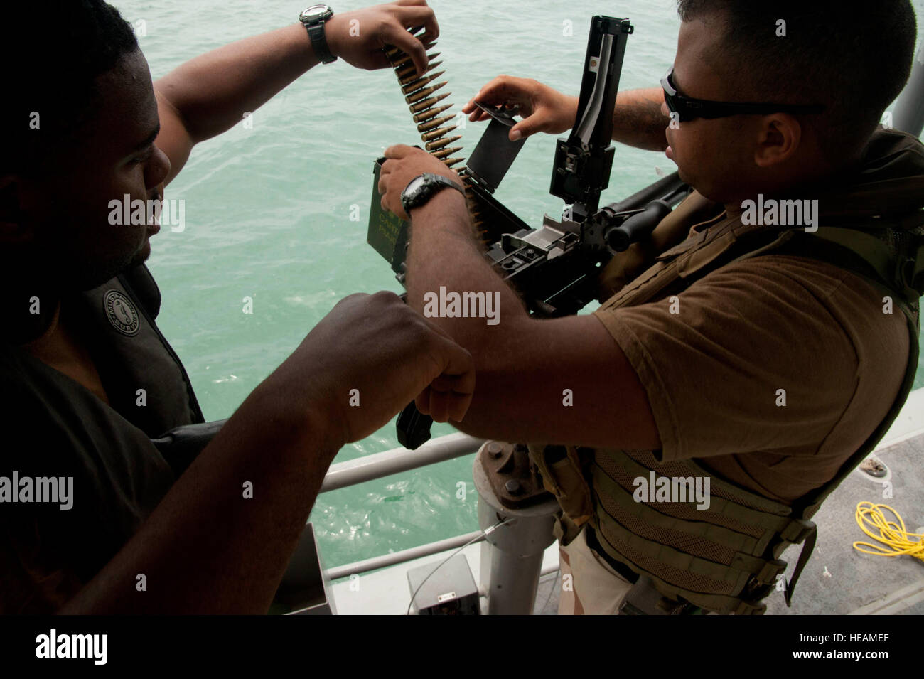 U.S. Navy petty officers inspect an M240B machine gun on a Maritime ...