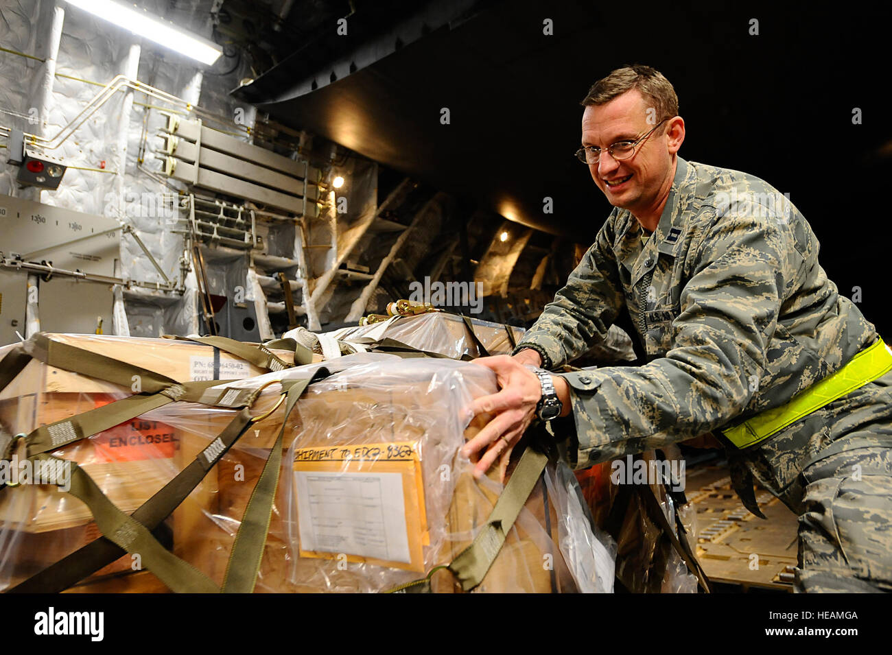 Chaplain (Capt.) Douglas Collins helps push cargo on board a C-17 ...