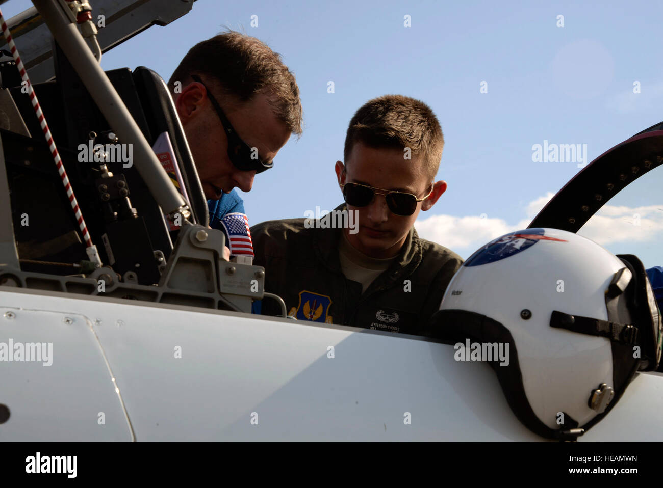 Air Force Lt. Col. Hague, NASA astronaut, (left), shows the controls of ...