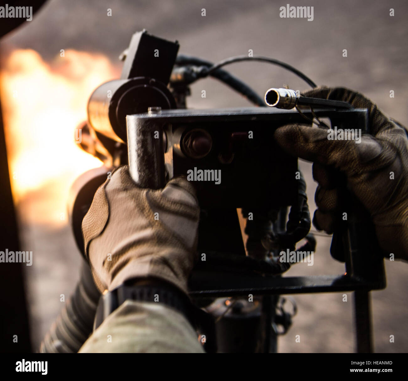An aerial gunner with the 303rd Expeditionary Rescue Squadron arms ...
