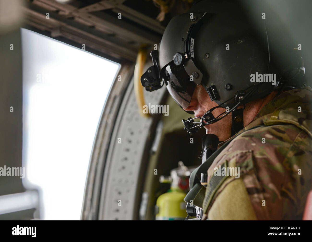 A 303rd Expeditionary Rescue Squadron flight engineer observes the area ...