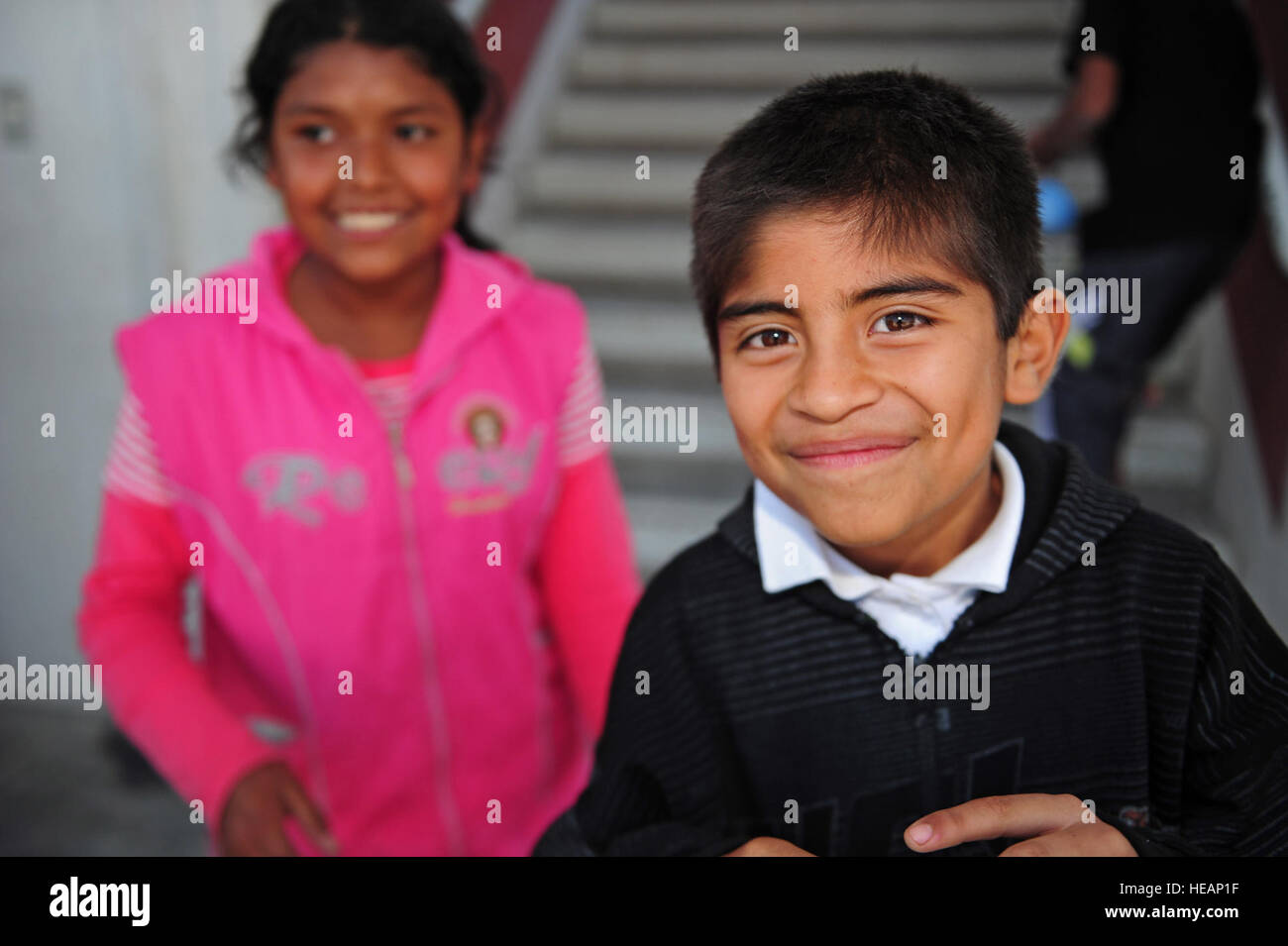 Two Peruvian children smile as they wait to receive medical care during ...
