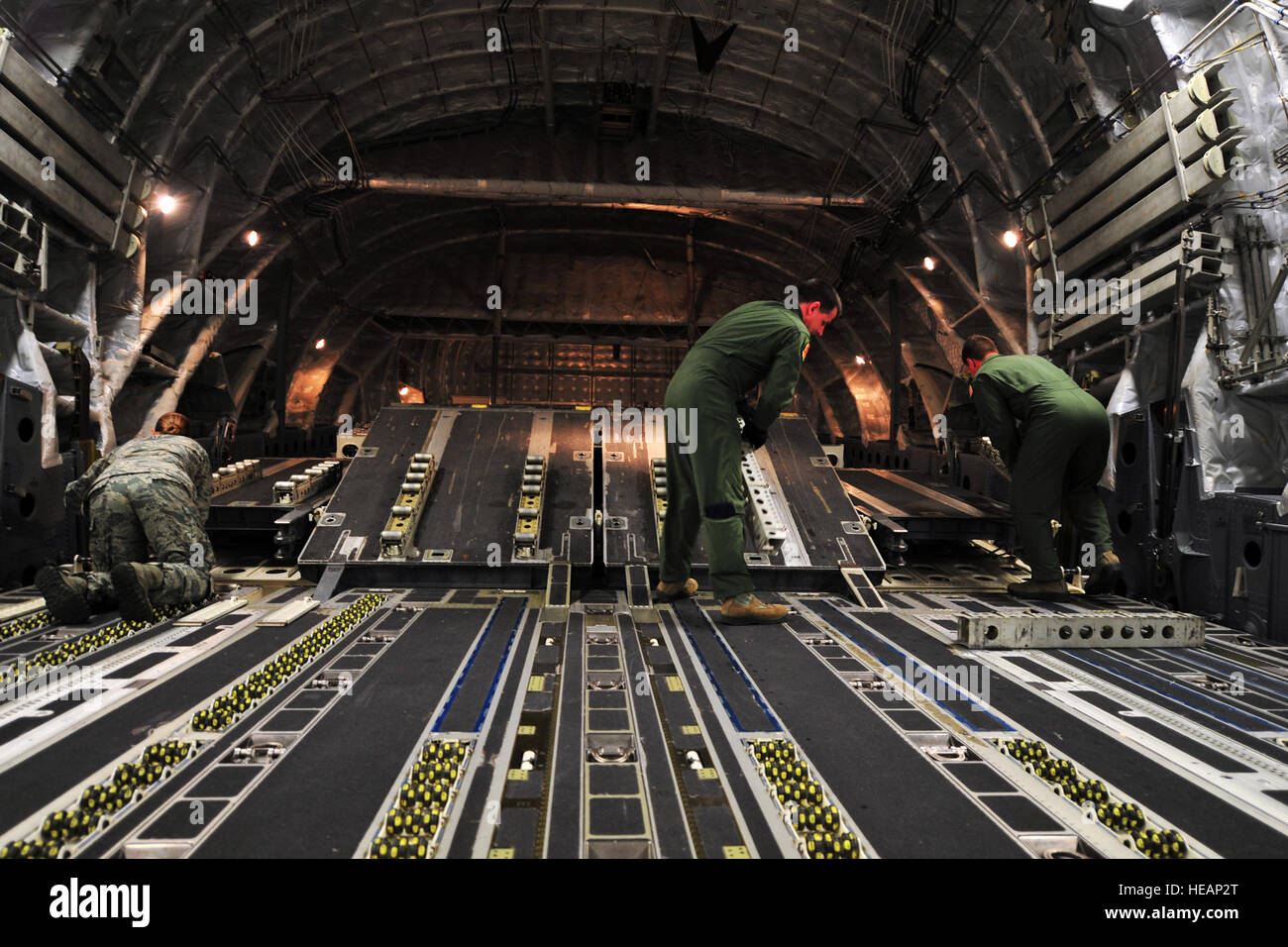 Loadmasters from the 316th Airlift Squadron flip cargo rollers on a C ...