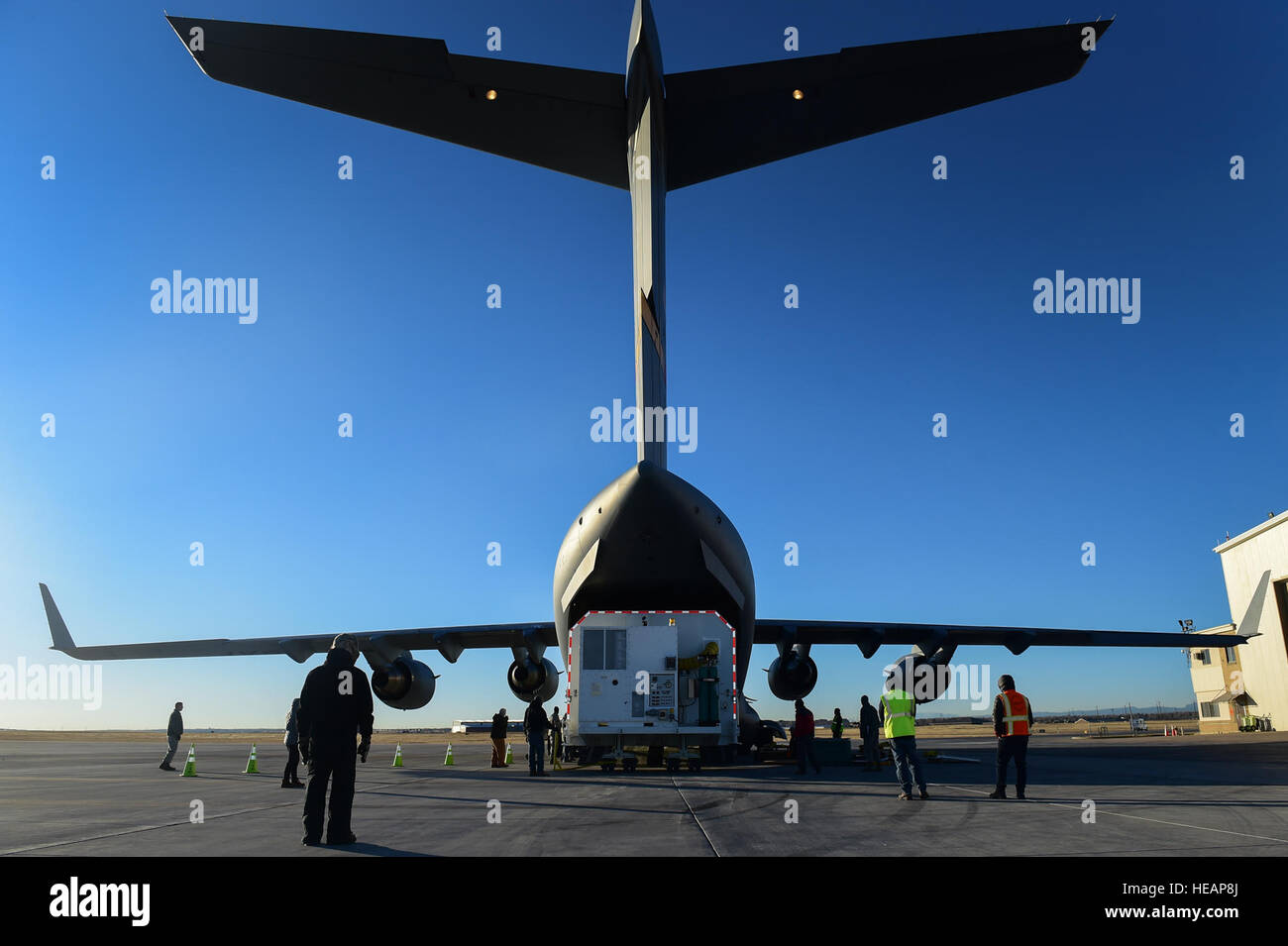 A C-17 Globemaster III remains taxied on the runway as members from ...