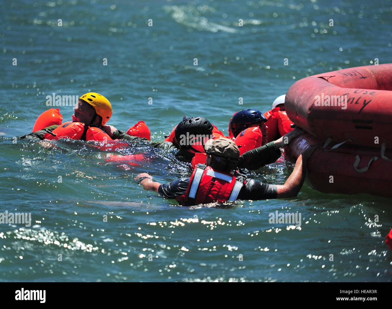 U.S. Air Force aircrew members gather around a large life raft during a ...