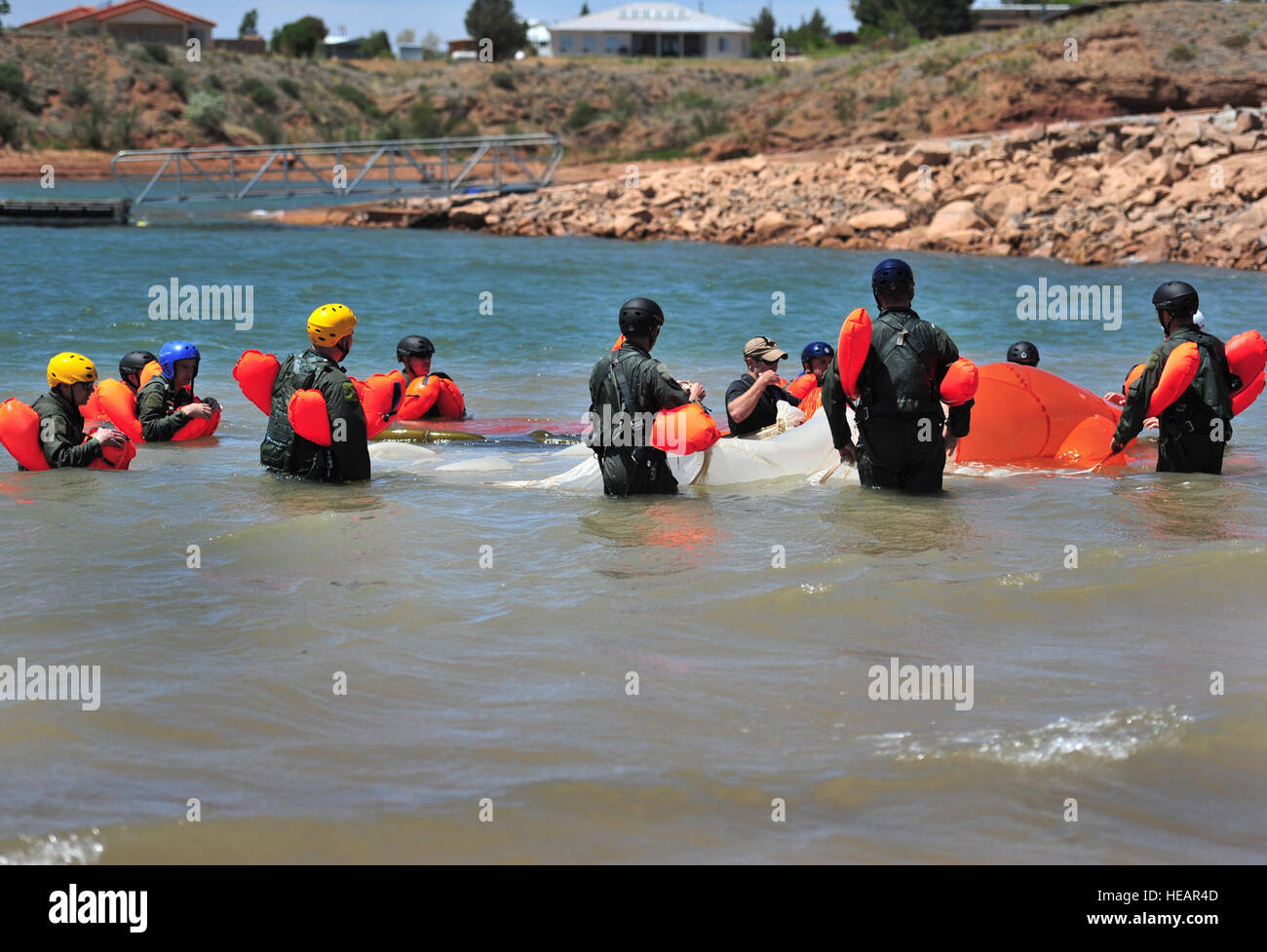 U.S. Air Force aircrew members stand near shore while practicing canopy ...