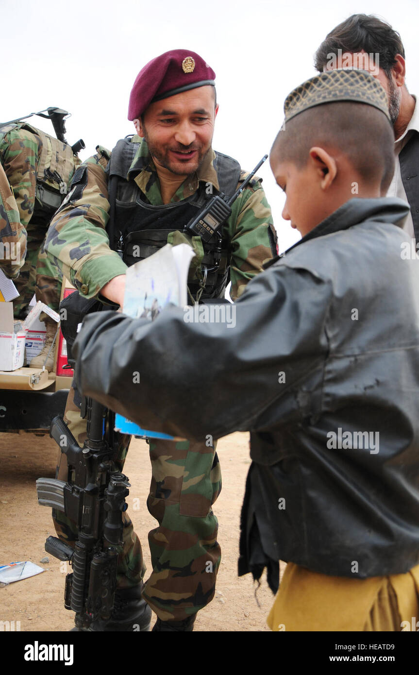 An Afghan National Army Commando distributes school supplies to ...