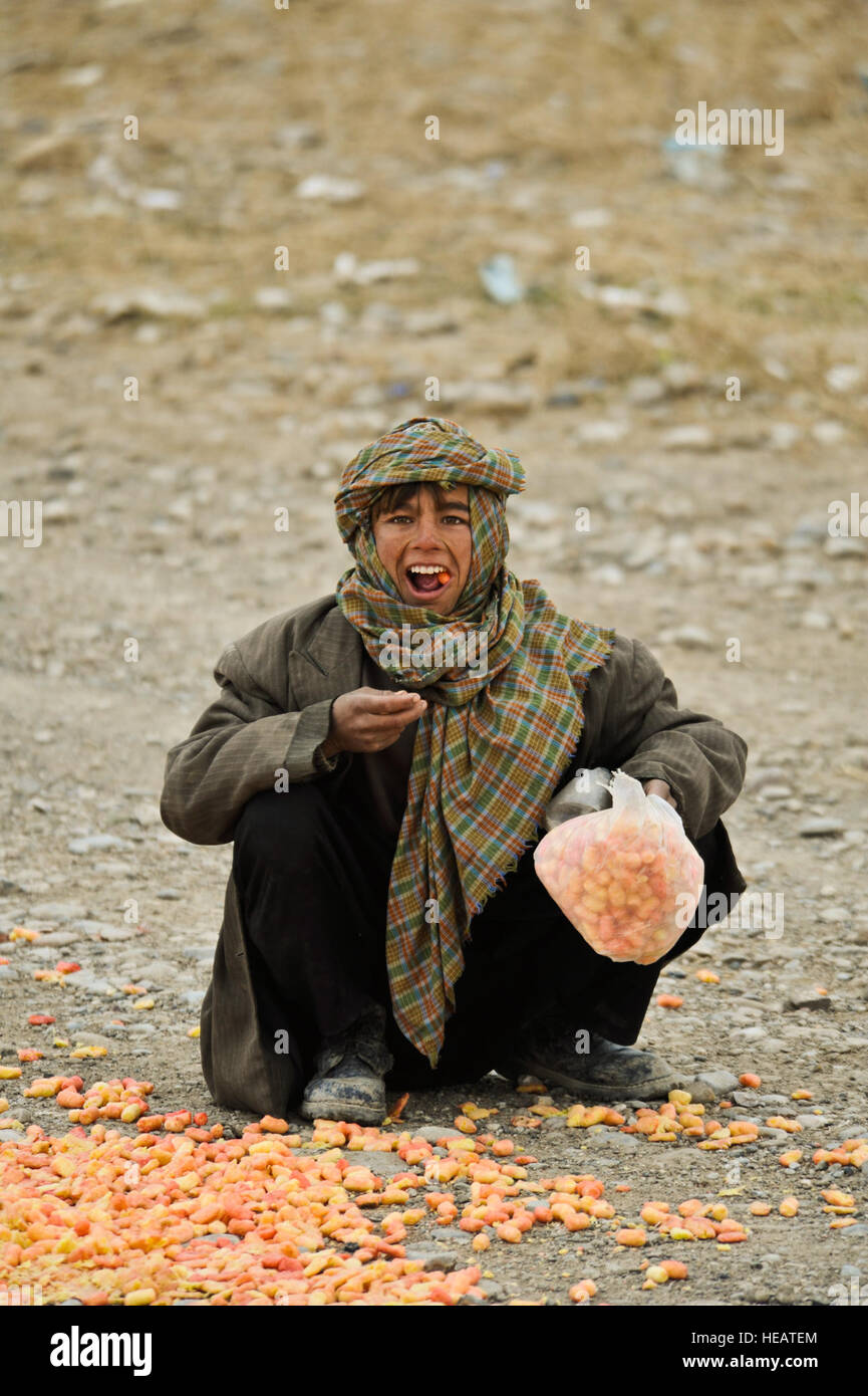 An Afghan boy eats popcorn near Highway 4 outside Kandahar Airfield ...