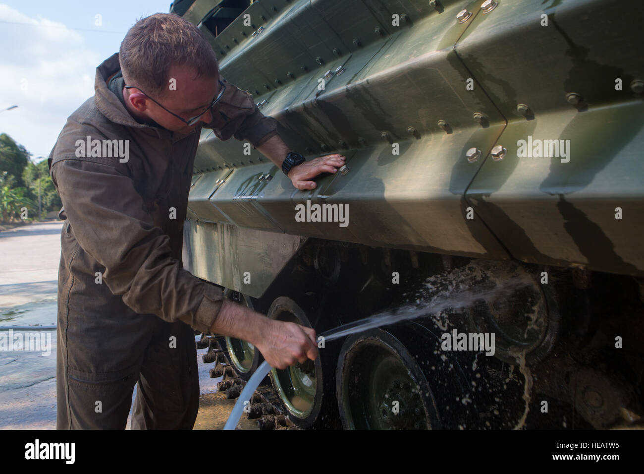 U.S. Marine Corps Lance Cpl. Kendrick Helms washes the mud from under ...