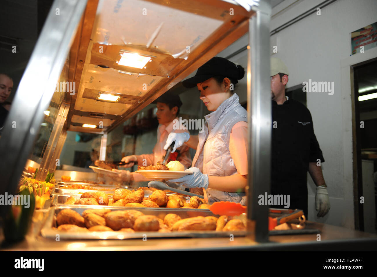 Dining Facility workers serve food prepared by Outback Steakhouse ...