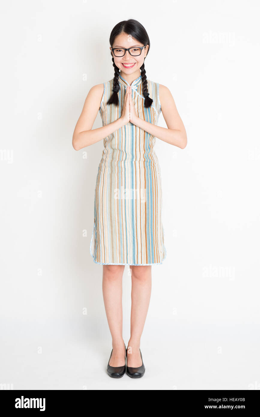 Portrait of young Asian girl in traditional qipao dress in greeting ...