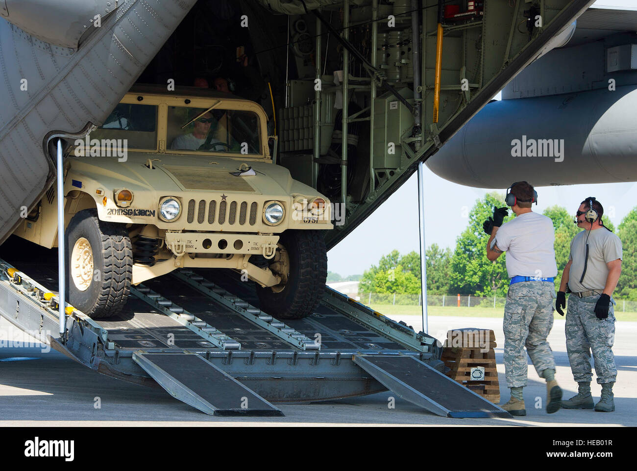 Air Force personnel guide a C-130 Hercules during an aerial port engine ...