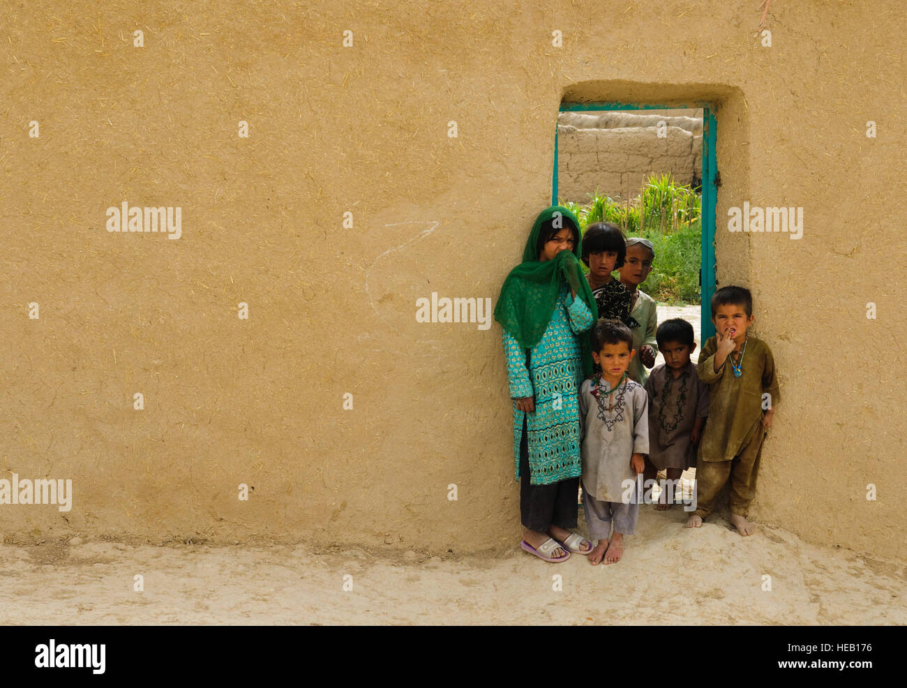 Afghan children watch from their front door as members of Provincial ...