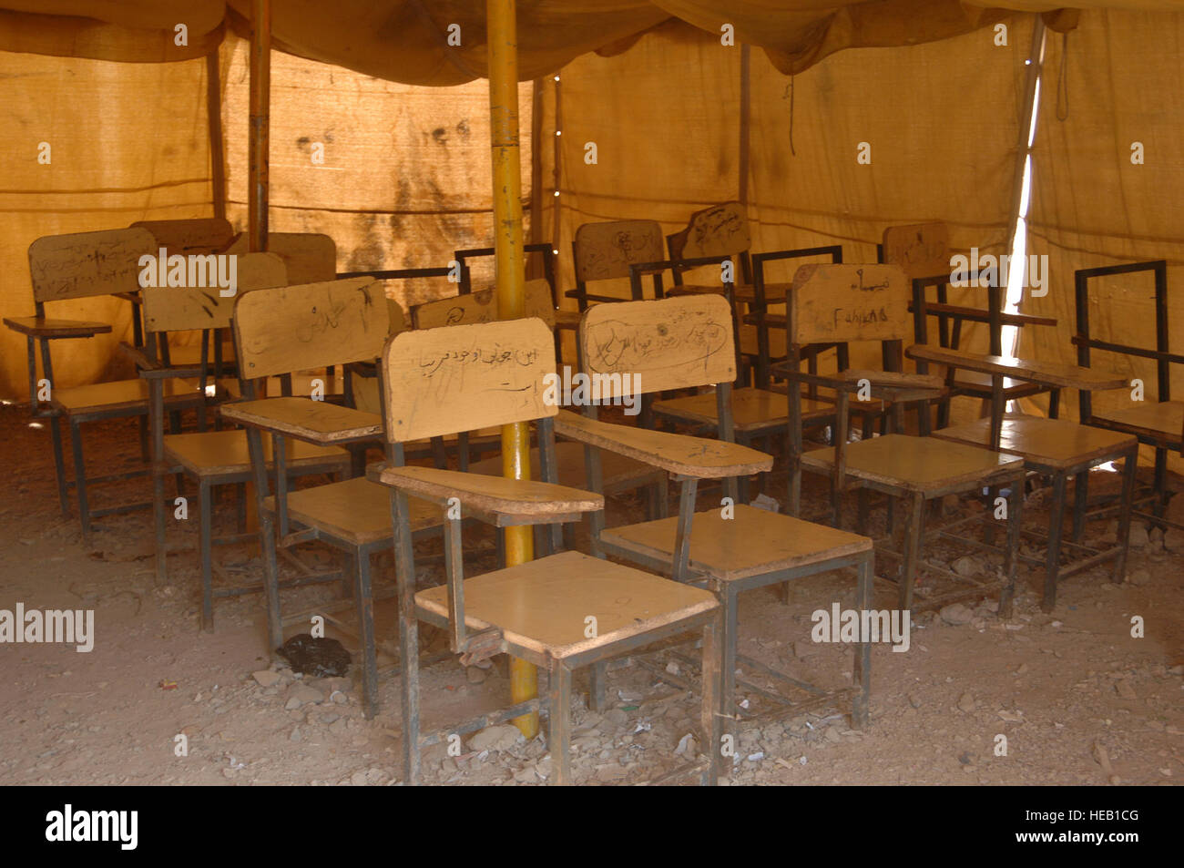 Broken-down wooden desks are jammed tightly together inside one of the ...