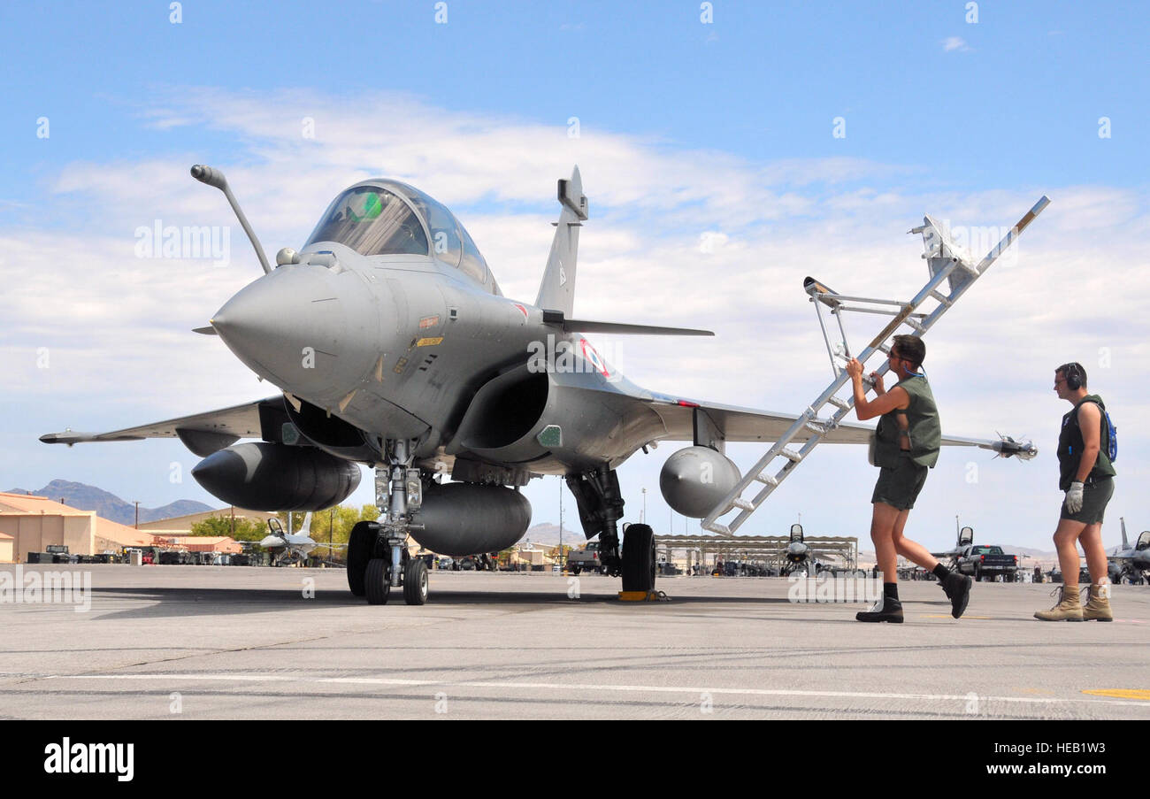 French air force ground crewmen provide a boarding ladder for a Rafale ...