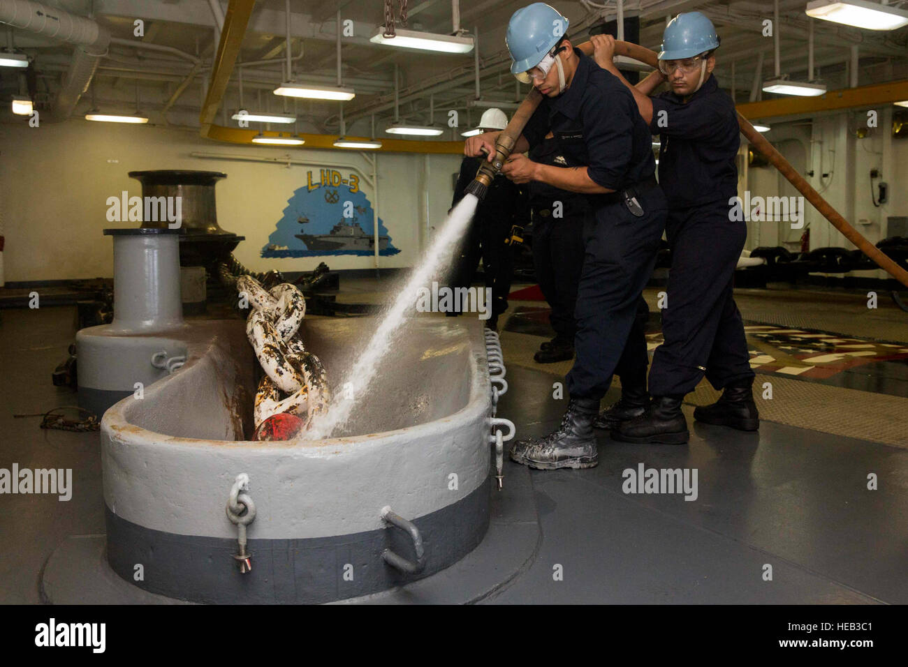 Sailors wash the anchor chain aboard the amphibious assault ship USS ...