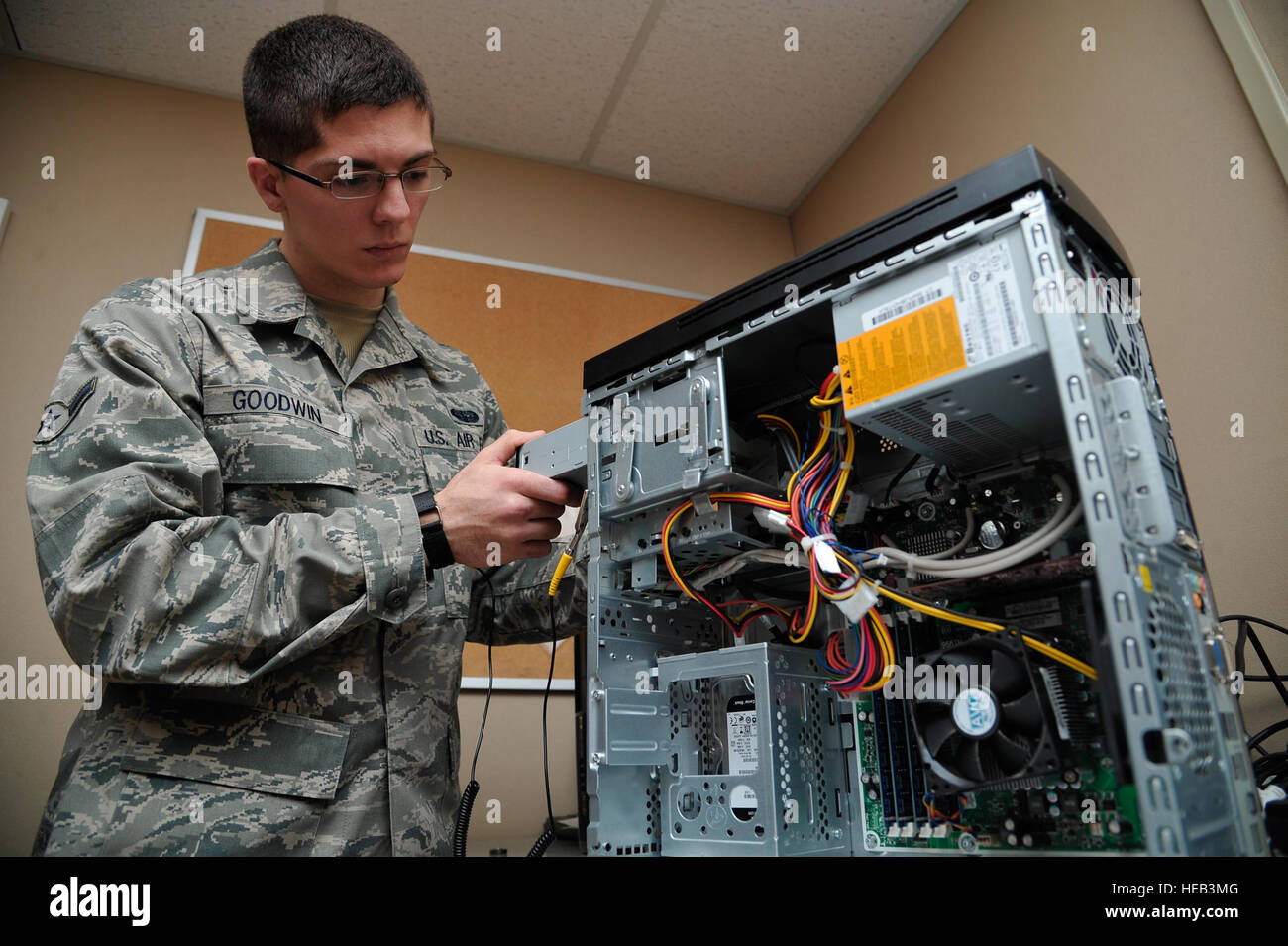 U.S. Air Force Airman Justin Goodwin installs an optical drive on a ...