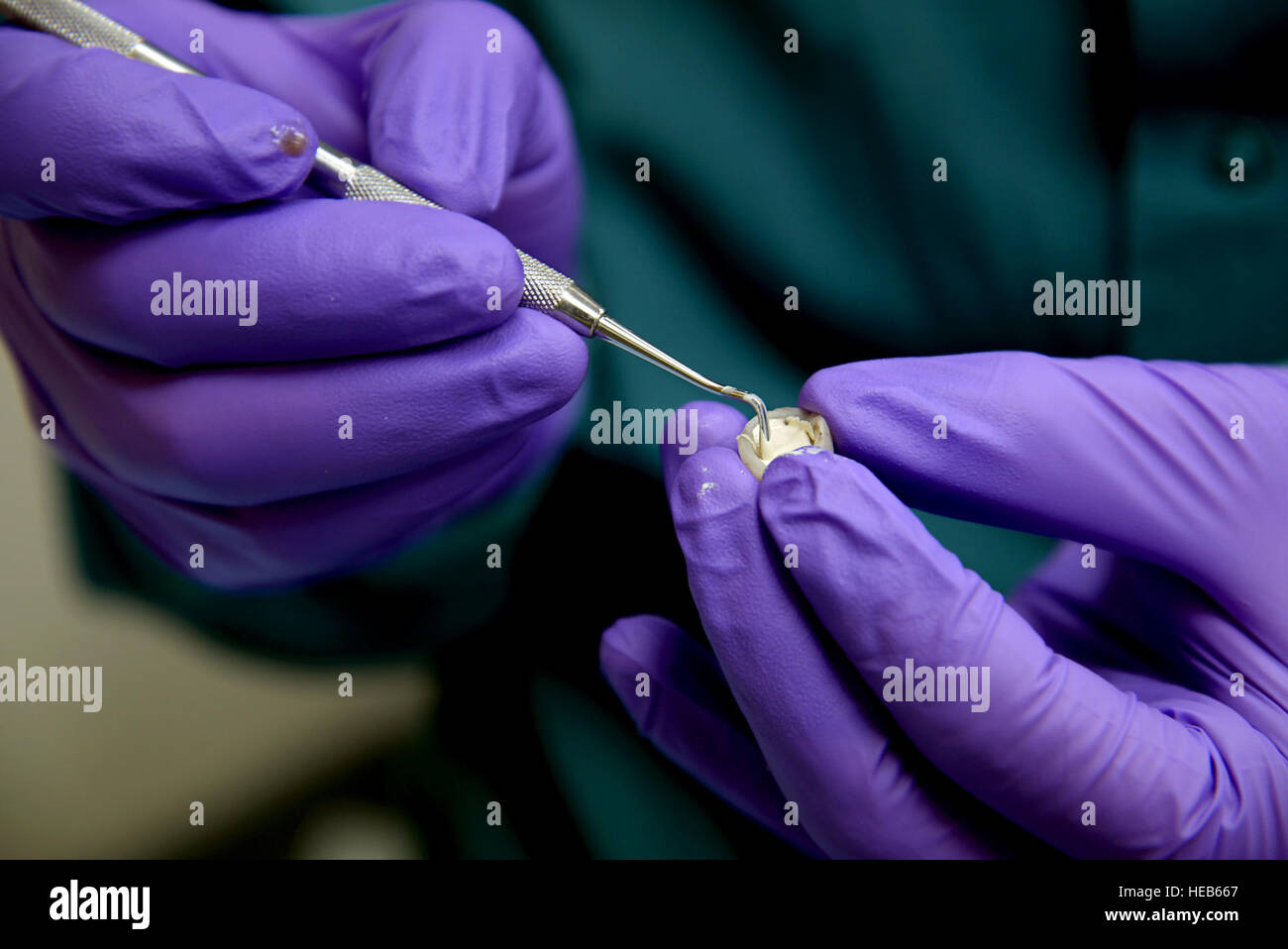 A dental technician from the 48th Dental Squadron applies cement to a ...