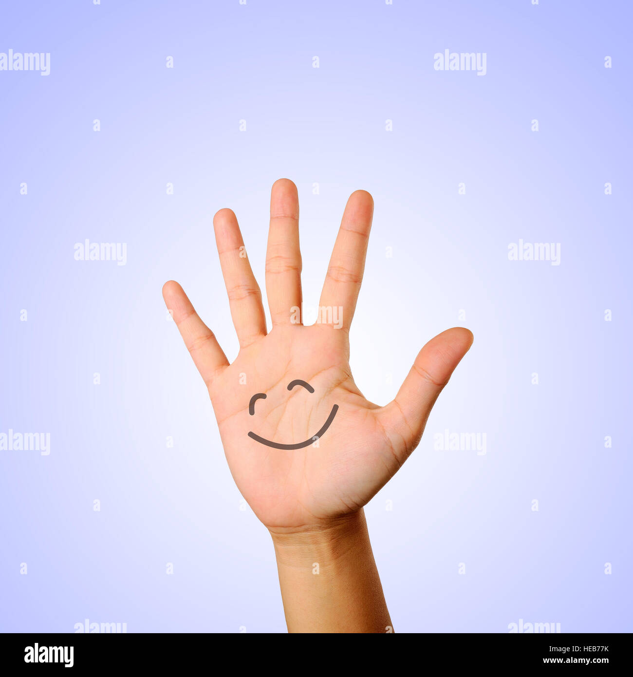Hand with smiley palm face icon on blue background Stock Photo - Alamy