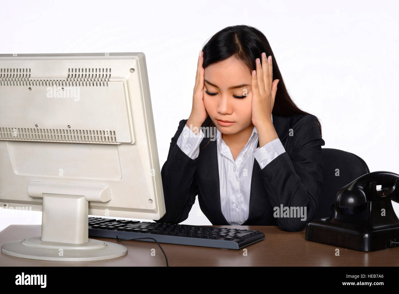 A young businesswoman is looking stressed as she works at her computer ...