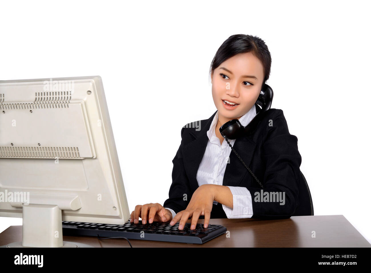Attractive young business woman sitting, using computer, talking on the ...