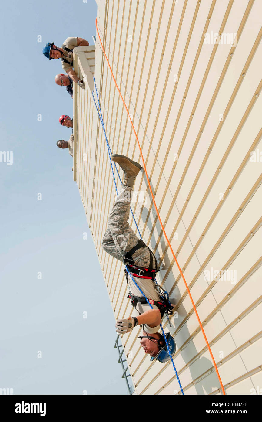 An Airman from the 5th Civil Engineer Squadron hangs upside down during ...