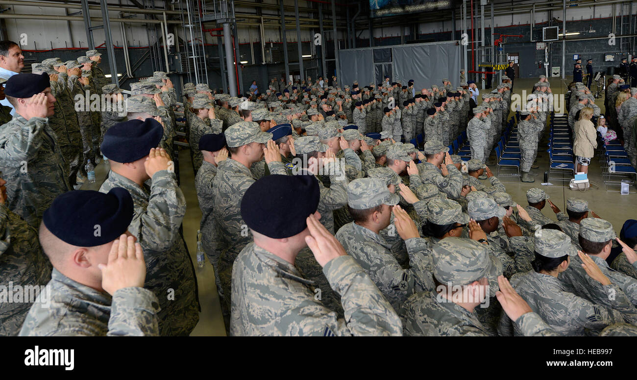 Airmen salute while the base honor guard posts the colors during the ...