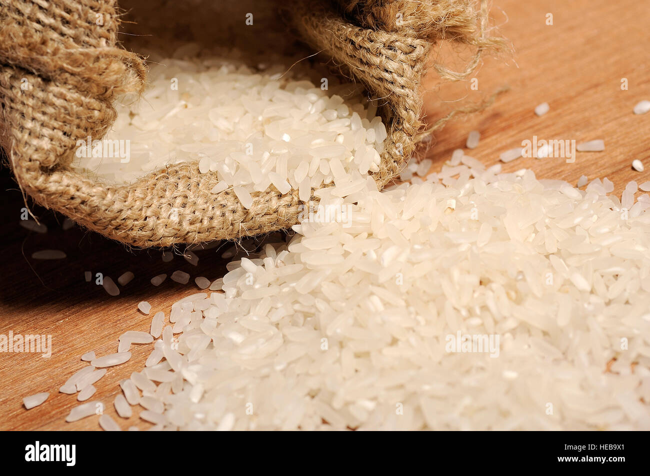 Raw white rice grains in burlap bag Stock Photo - Alamy