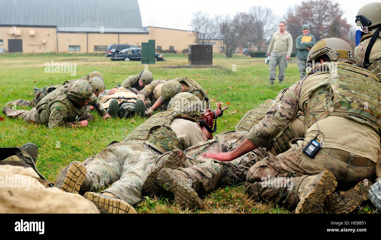 Explosive ordnance Airmen use a low crawl to transport a simulated ...