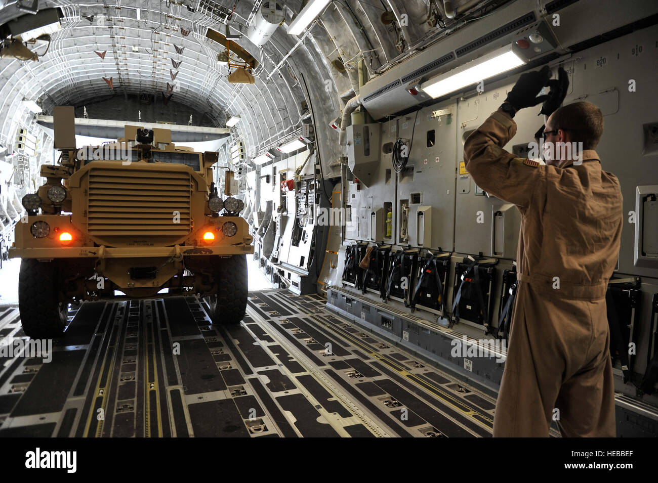 A military mine-resistant ambush protected (MRAP) vehicle is loaded ...