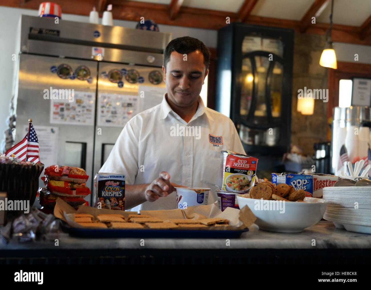 Sarhad Aziz, United Service Organization duty manager, places snacks ...