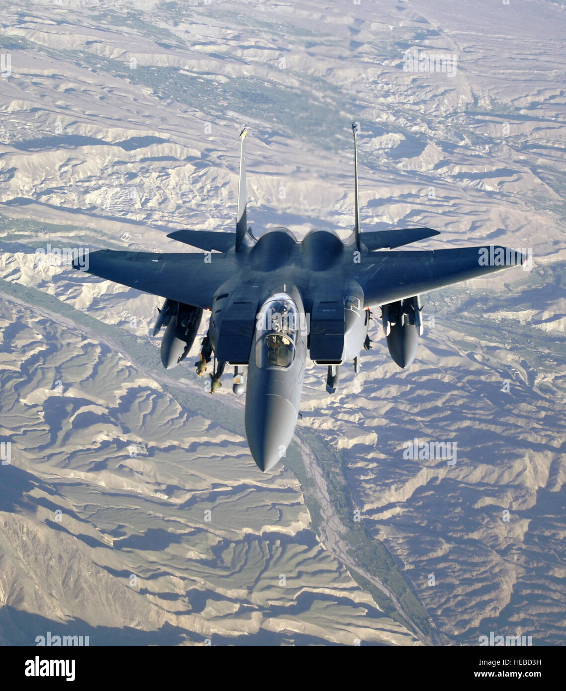 An F-15E Strike Eagle soars over the mountains and high desert of ...