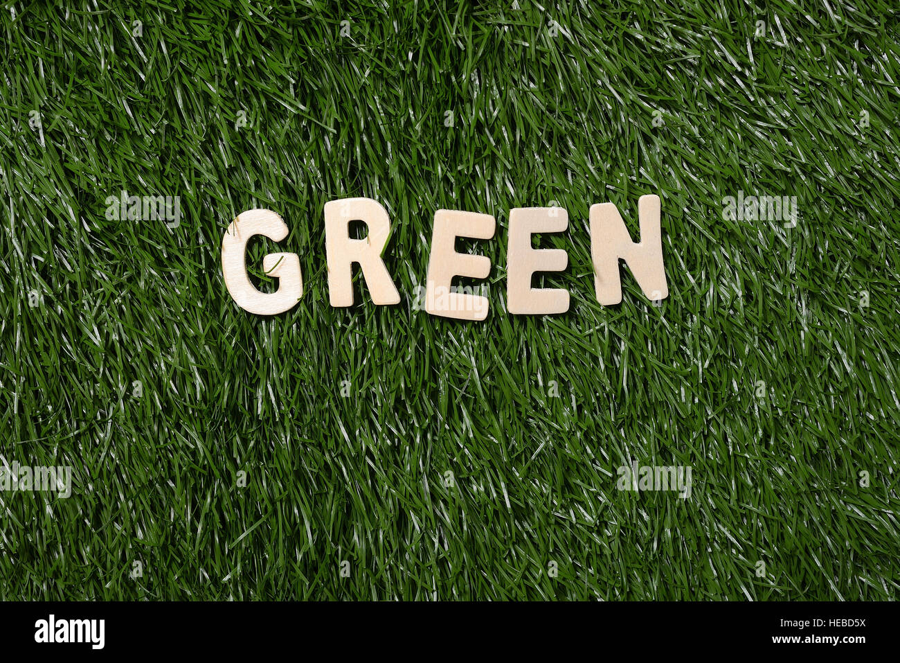Green wooden sign on green grass background Stock Photo - Alamy