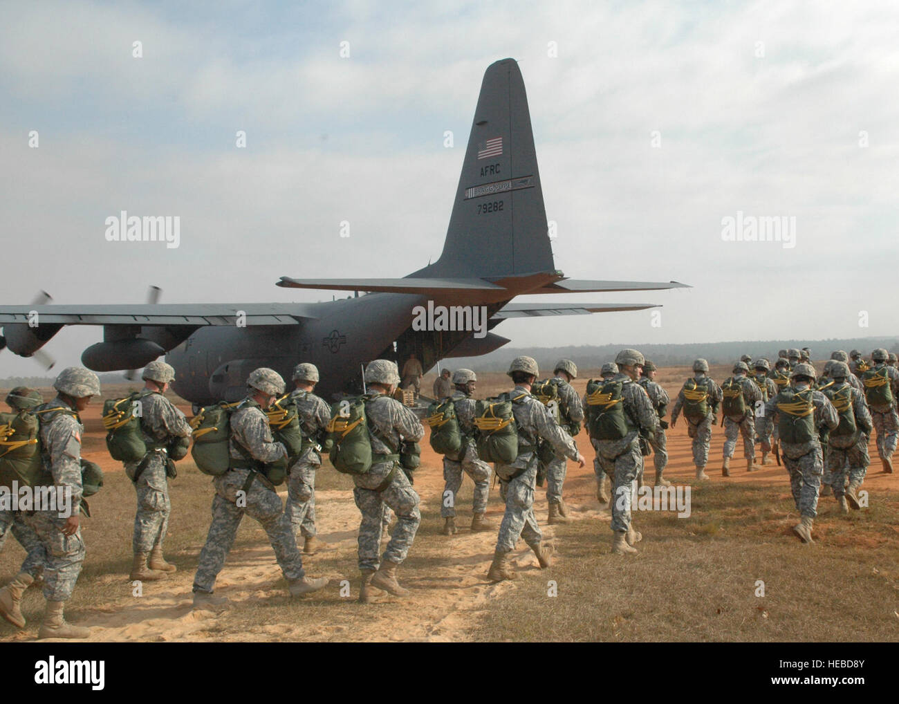 Fifty paratroopers walk to a C-130 with engines running during ...