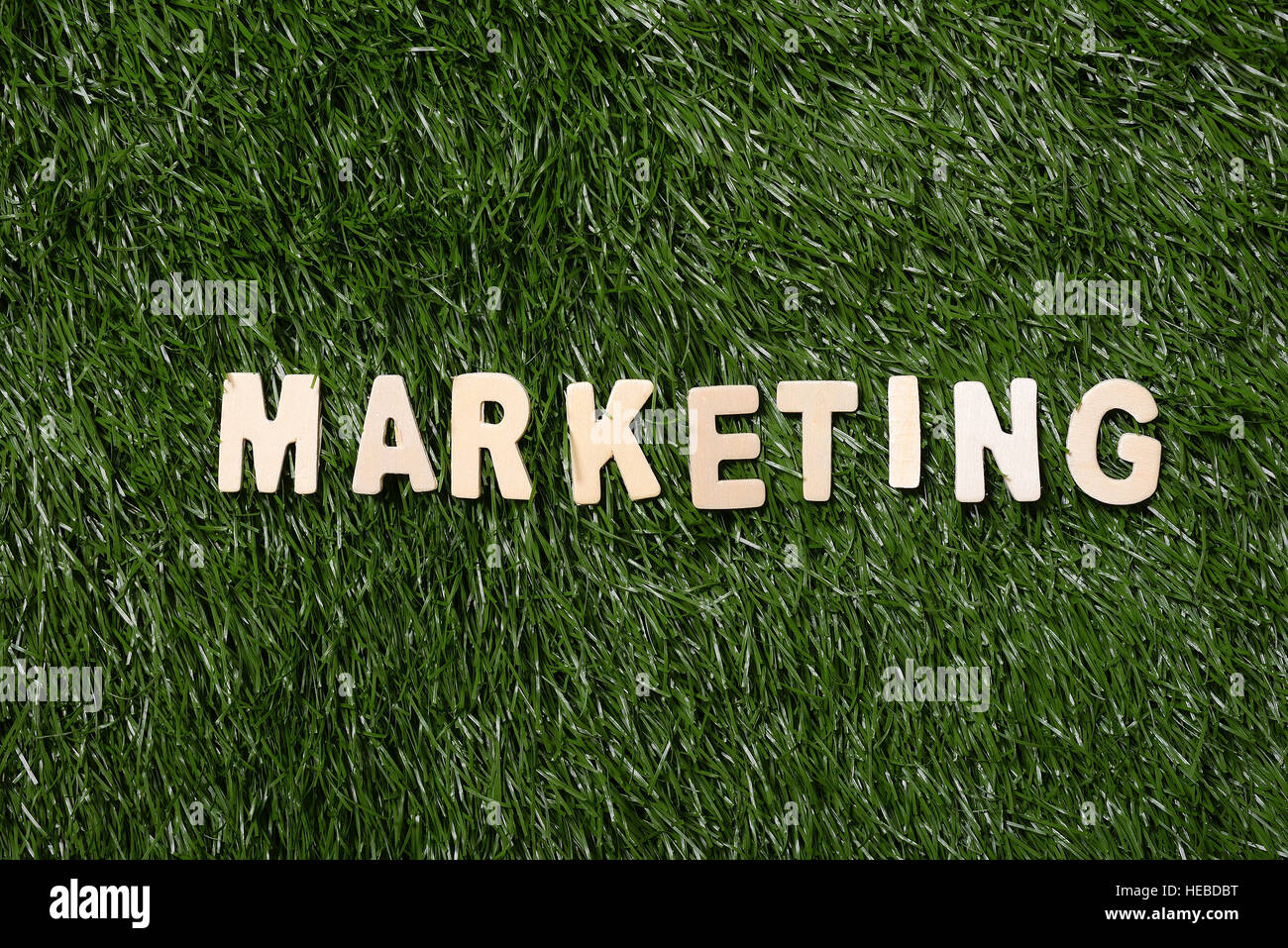 Marketing wooden sign on green grass background Stock Photo - Alamy