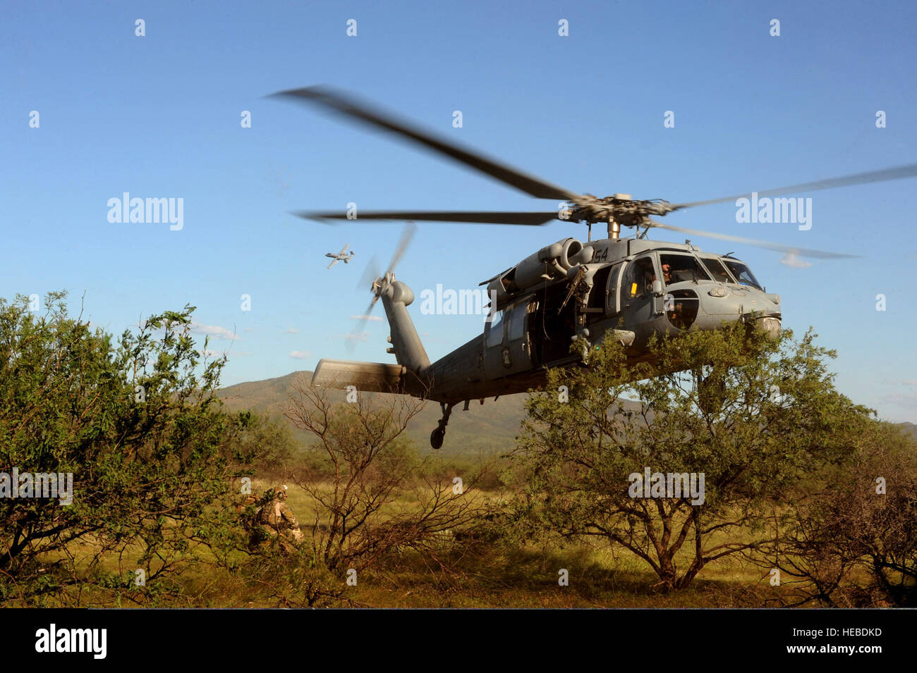 A pararescue jumper waits for the hoist line from the U.S. Navy MH-60S ...