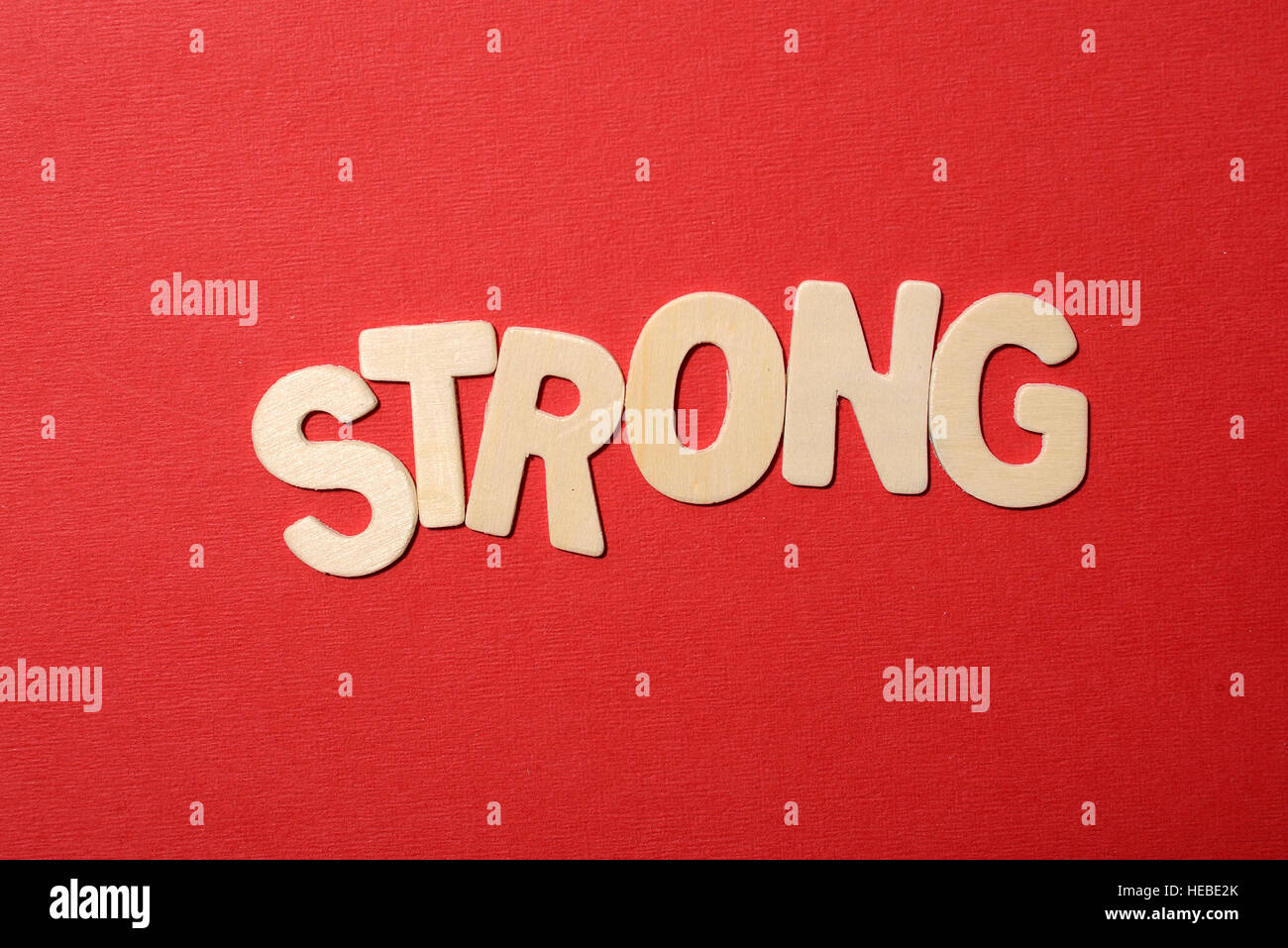 Strong text on red paper background Stock Photo - Alamy