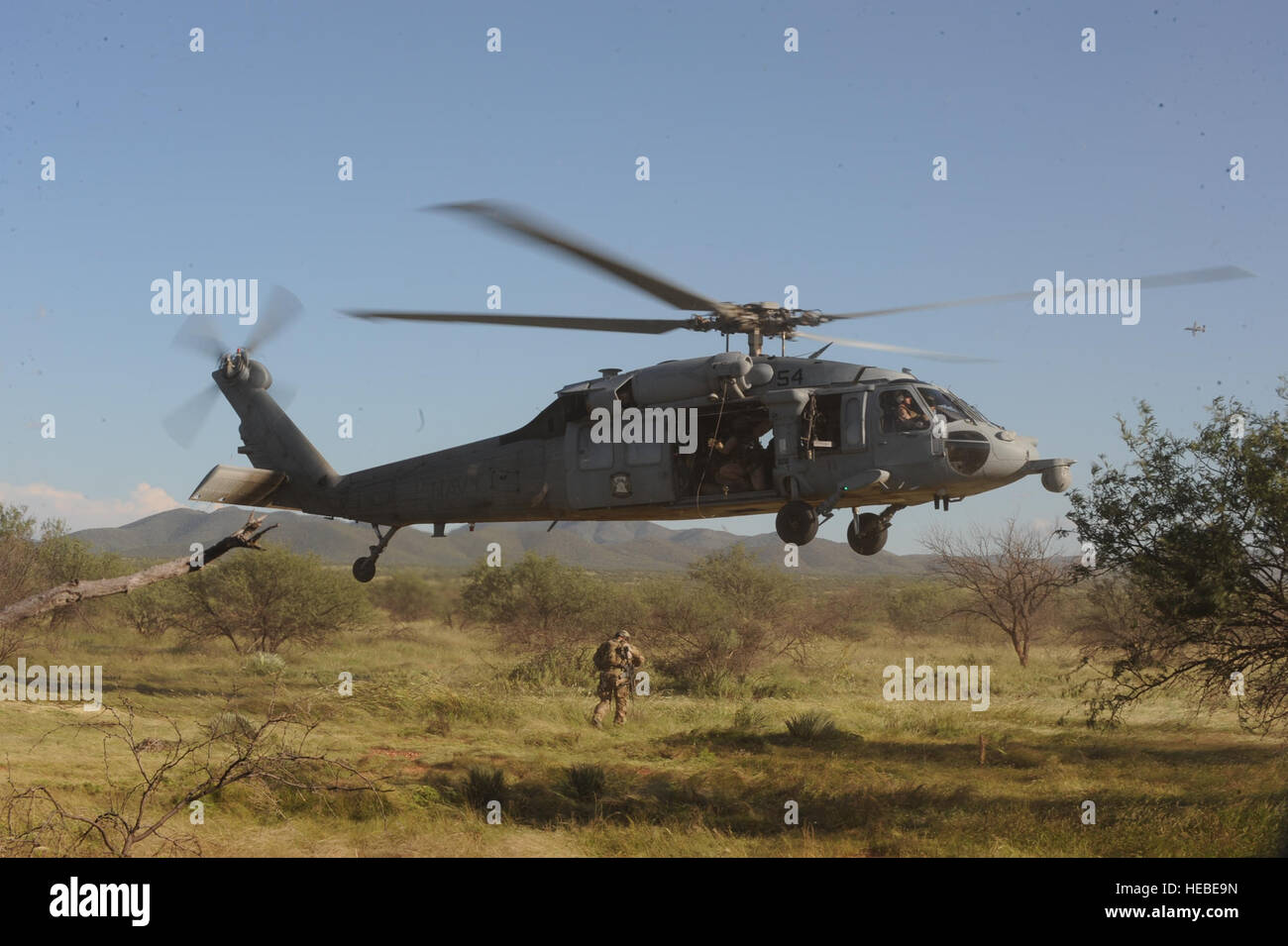 A pararescue jumper waits for the hoist line from the U.S. Navy MH-60S ...