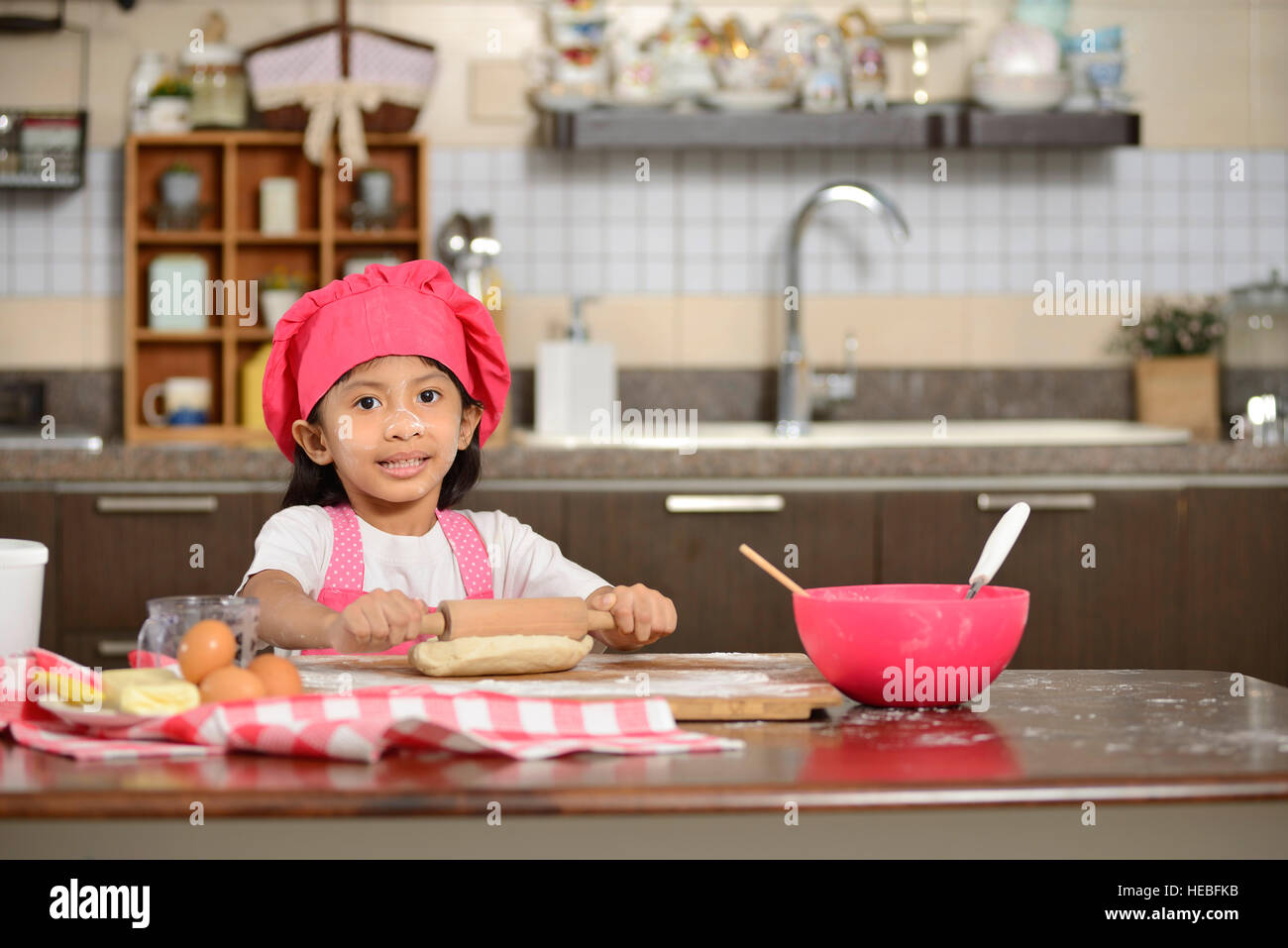 Little asian girl making dough in the kitchen Stock Photo - Alamy