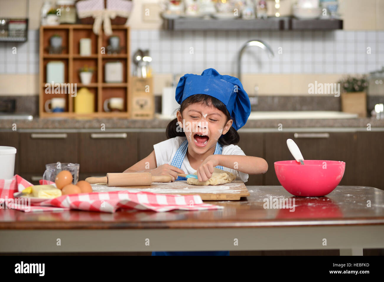 Little asian girl making dough in the kitchen Stock Photo - Alamy
