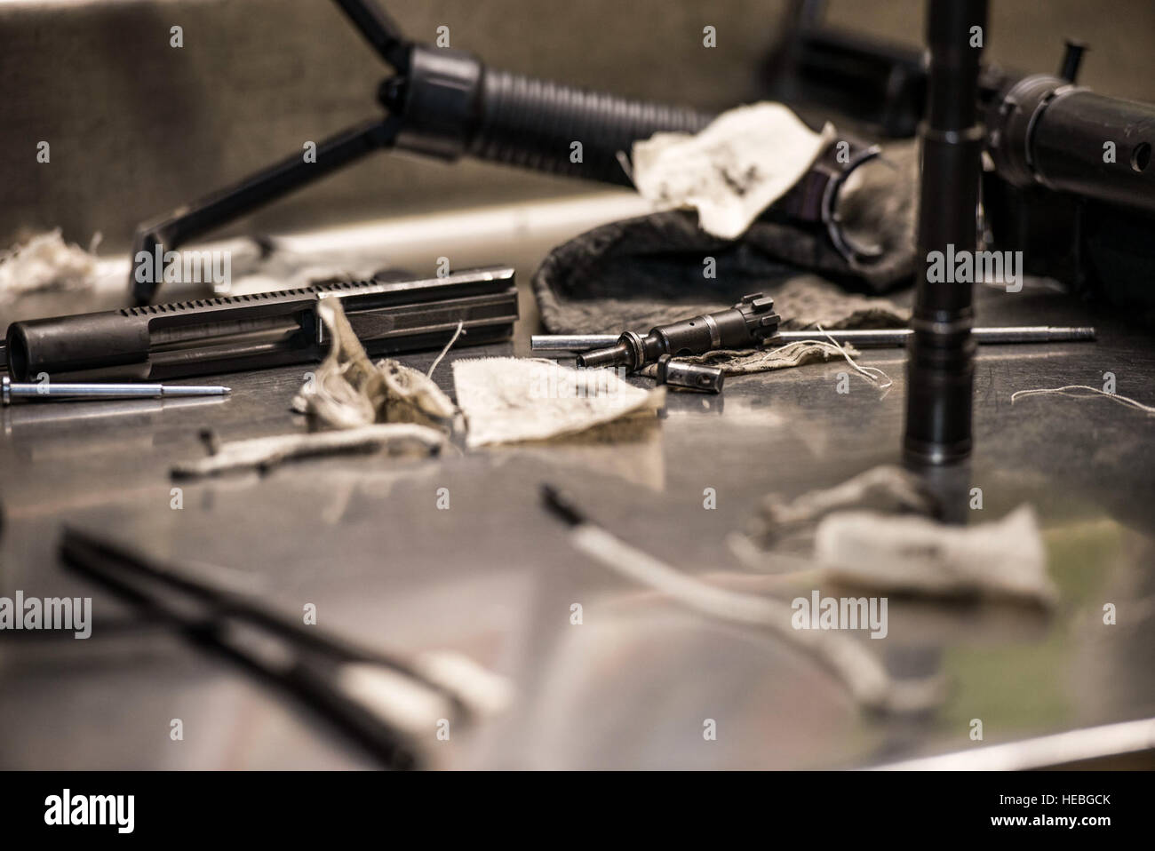 Pieces of a disassembled M4 carbine and cleaning supplies sit on a ...