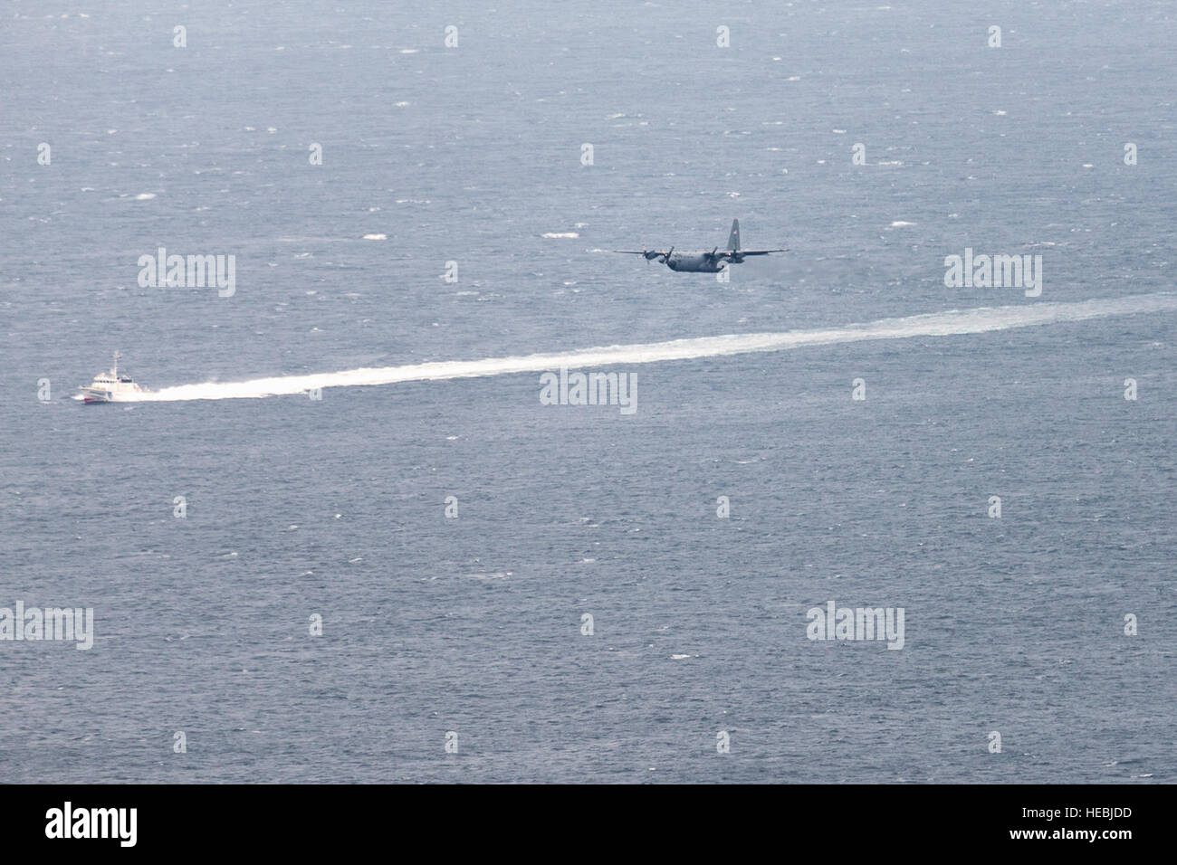 A vessel from Japan Coast Guard leads a C-130 Hercules from the 36th ...