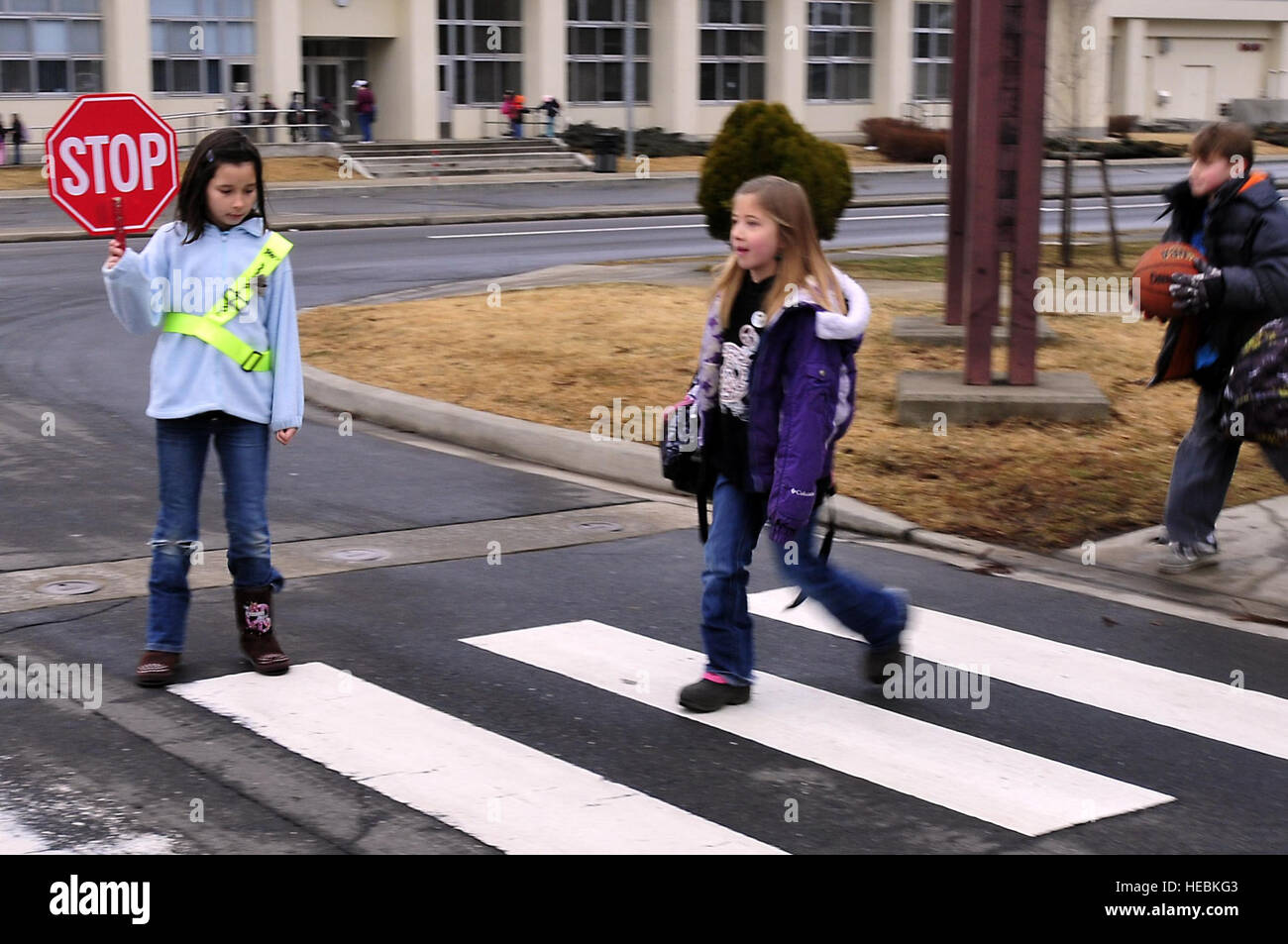 Student safety patrol volunteers assist younger students in safely ...
