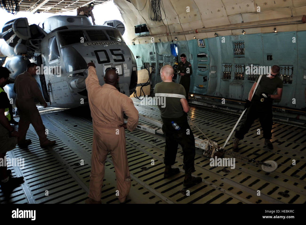 A U.S. Air Force C-5 galaxy crew and Marines load a CH-53 helicopter ...