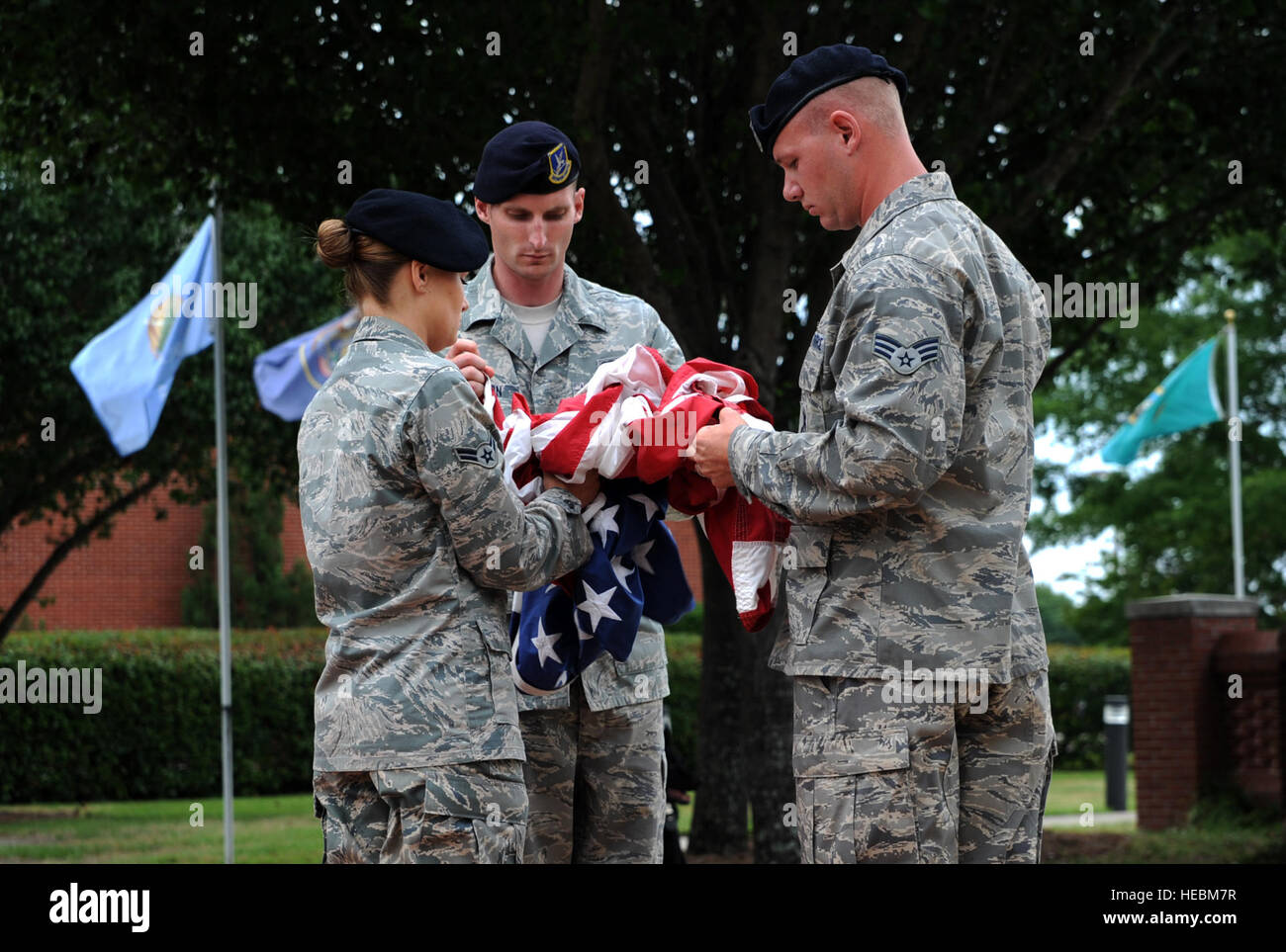 Airmen from the 628th Security Forces Squadron prepare to fold the flag ...