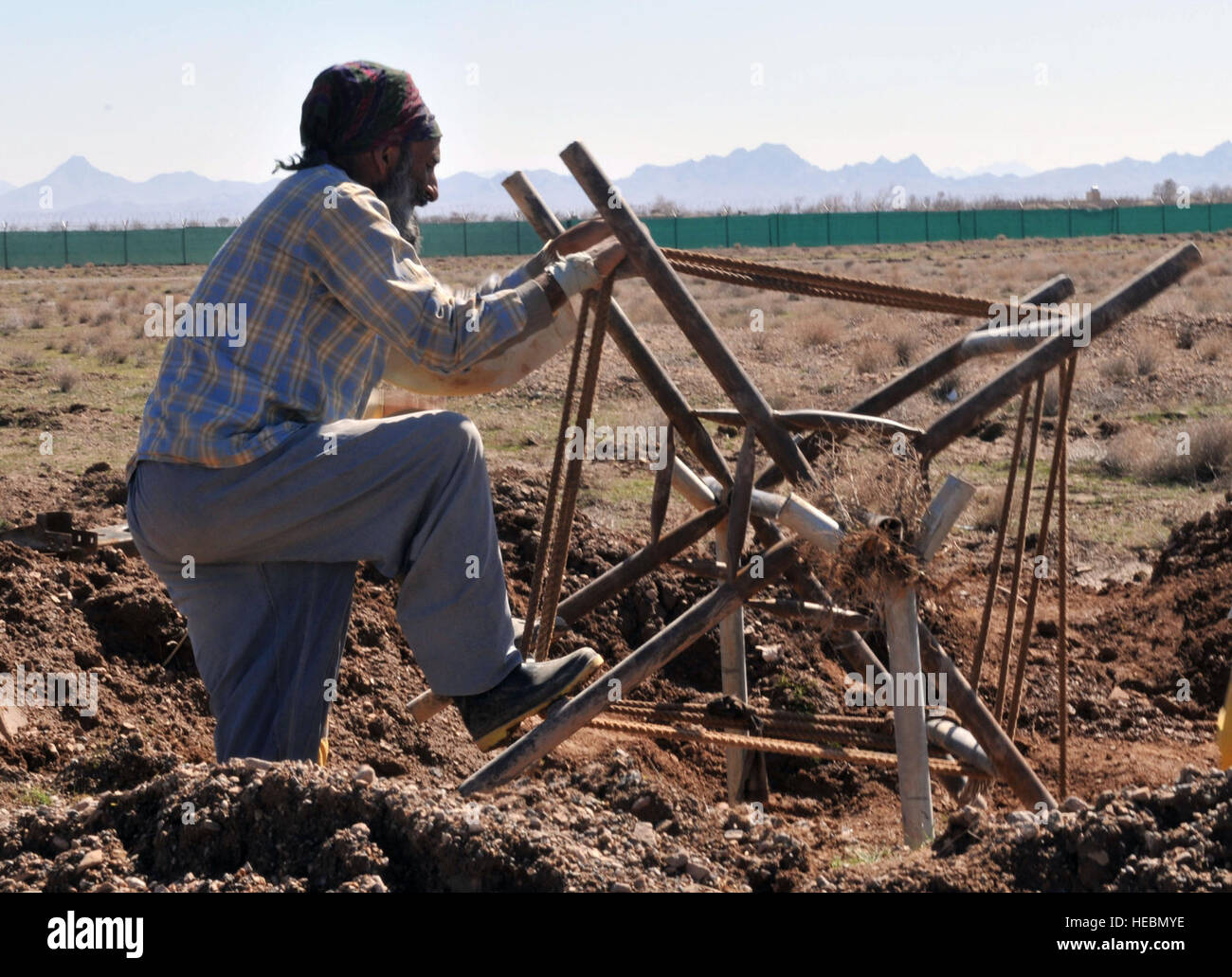 An Afghan worker utilizes a crank to lower a fellow worker into a Karez ...